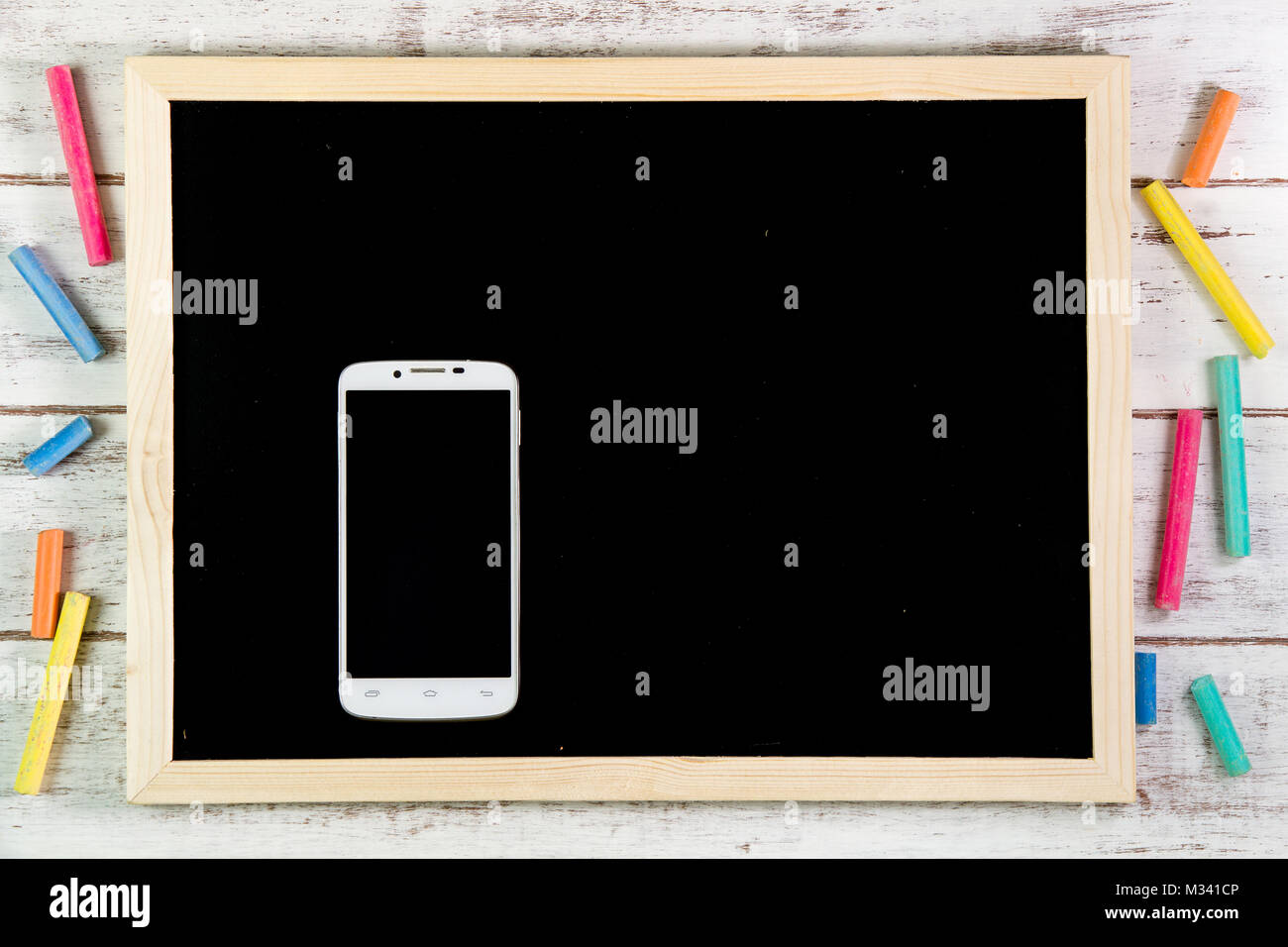Blank blackboard and smart phone on wooden table.Template mock up for ...