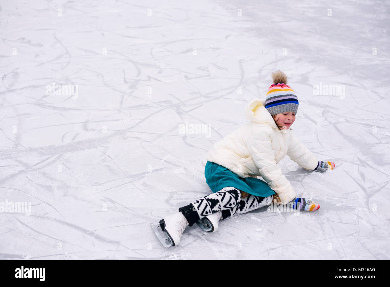 Girl who has fallen over ice skating Stock Photo - Alamy