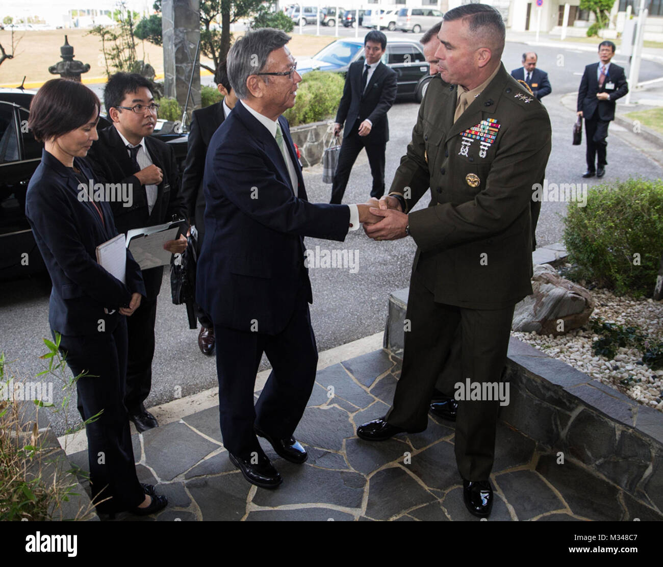 Takeshi Onaga, newly-elected Okinawa governor, left, shakes hands with ...