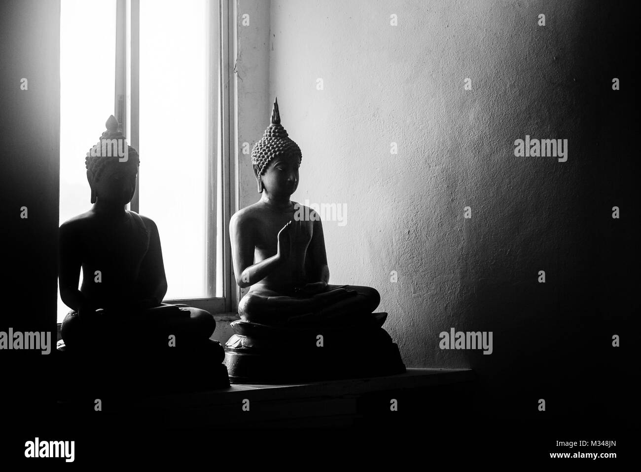 Abstract low key light image face of brass Buddha statue with ray of ...