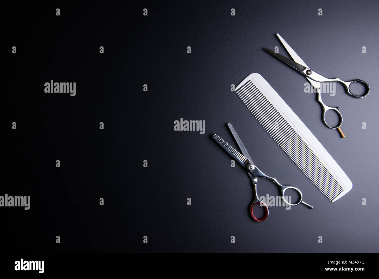 Stylish Professional Barber Scissors and white comb on black background ...