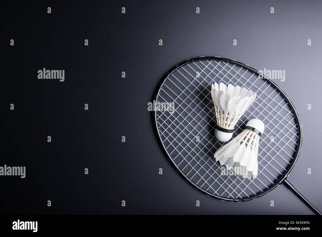 Two shuttlecocks and badminton racket on black background.Sport concept ...