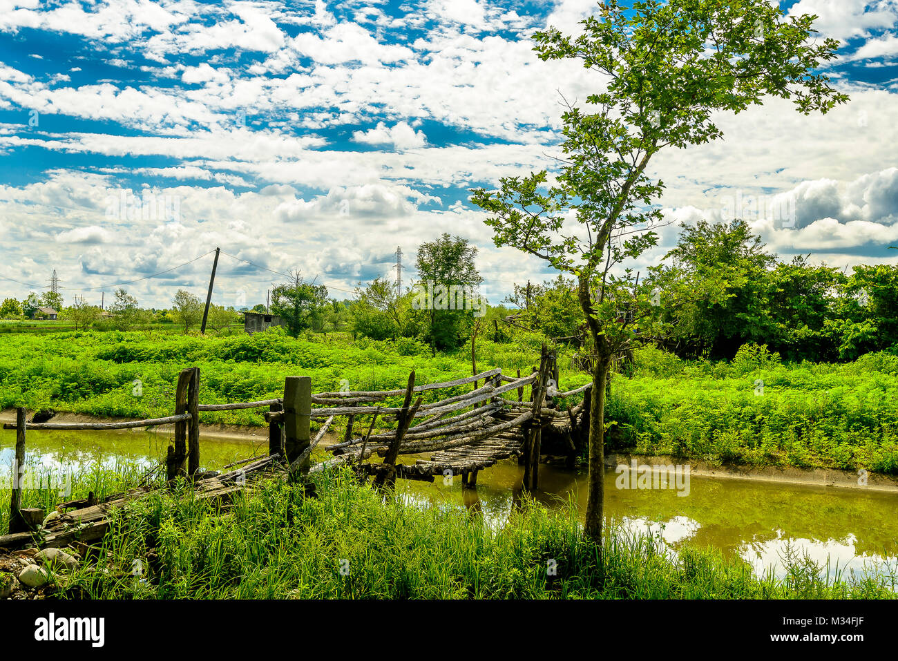 A rural scene with bridge in foreground, a small river running in ...