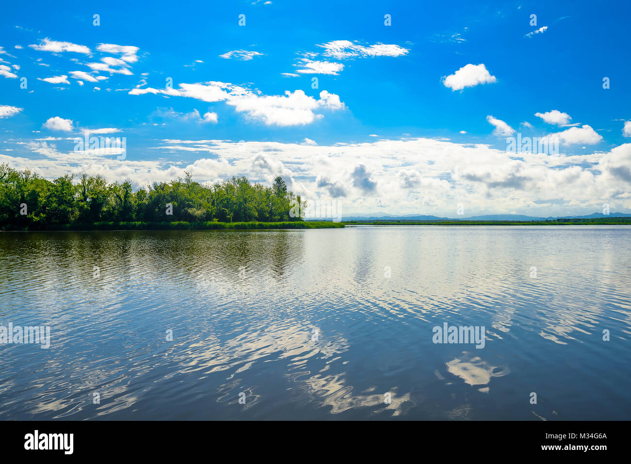 Wide angle lake landscape with trees, forest and clouds in the ...