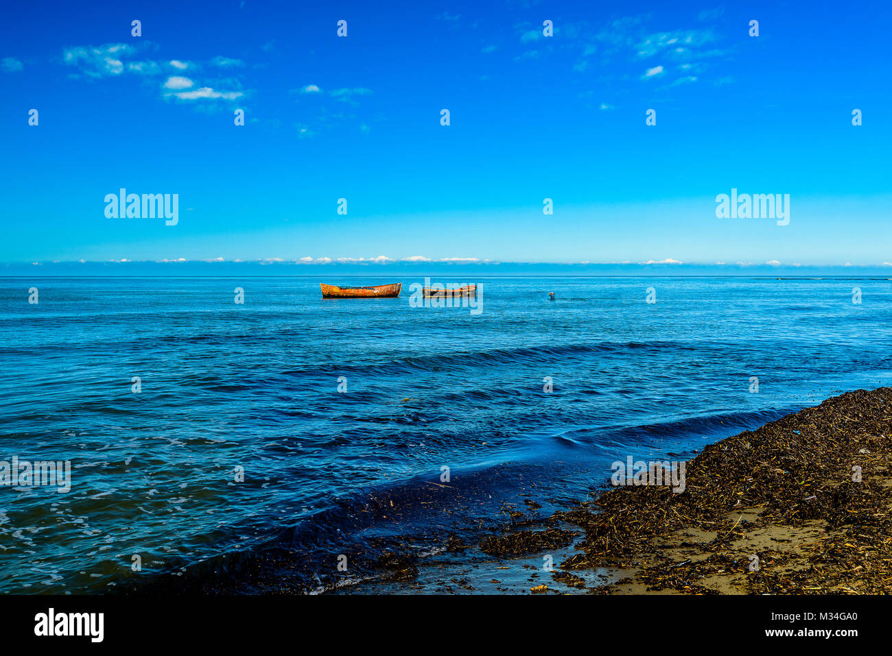 Wide angle landscape seascape showing fishing boats on a isolated beach ...