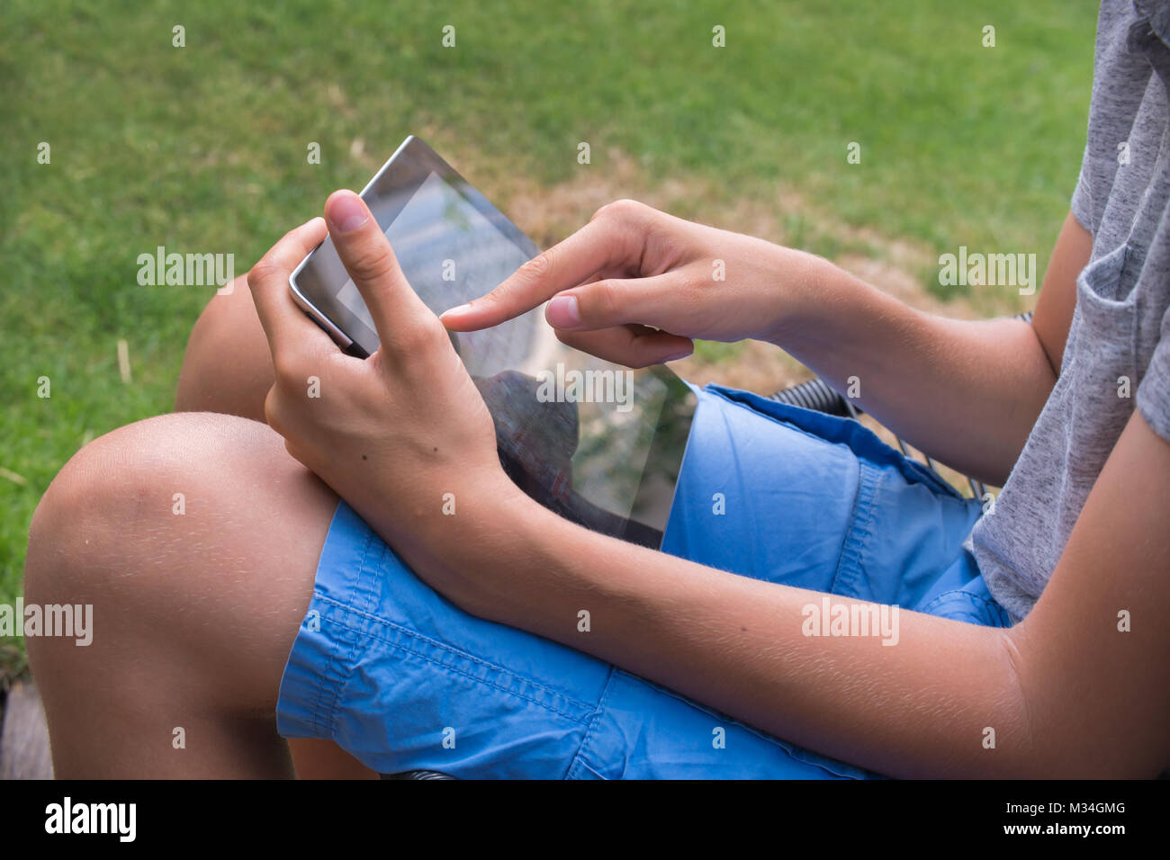 Boy with a tablet outdoor, green lawn background Stock Photo - Alamy