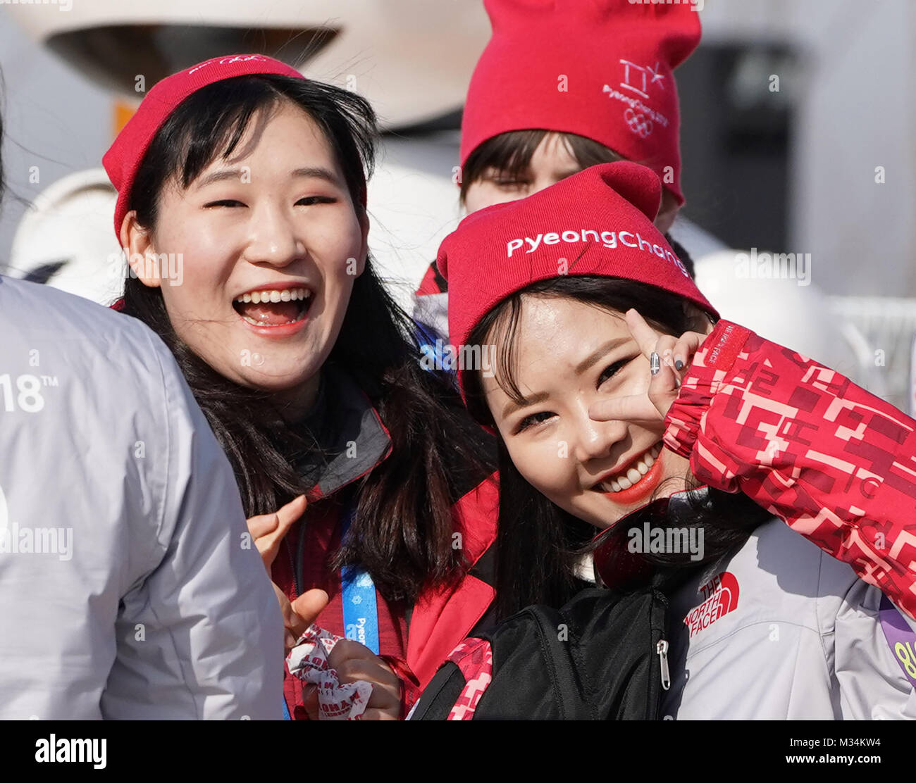 Pyeongchang, South Korea. 9th Feb, 2018. A volunteer (R) poses for ...