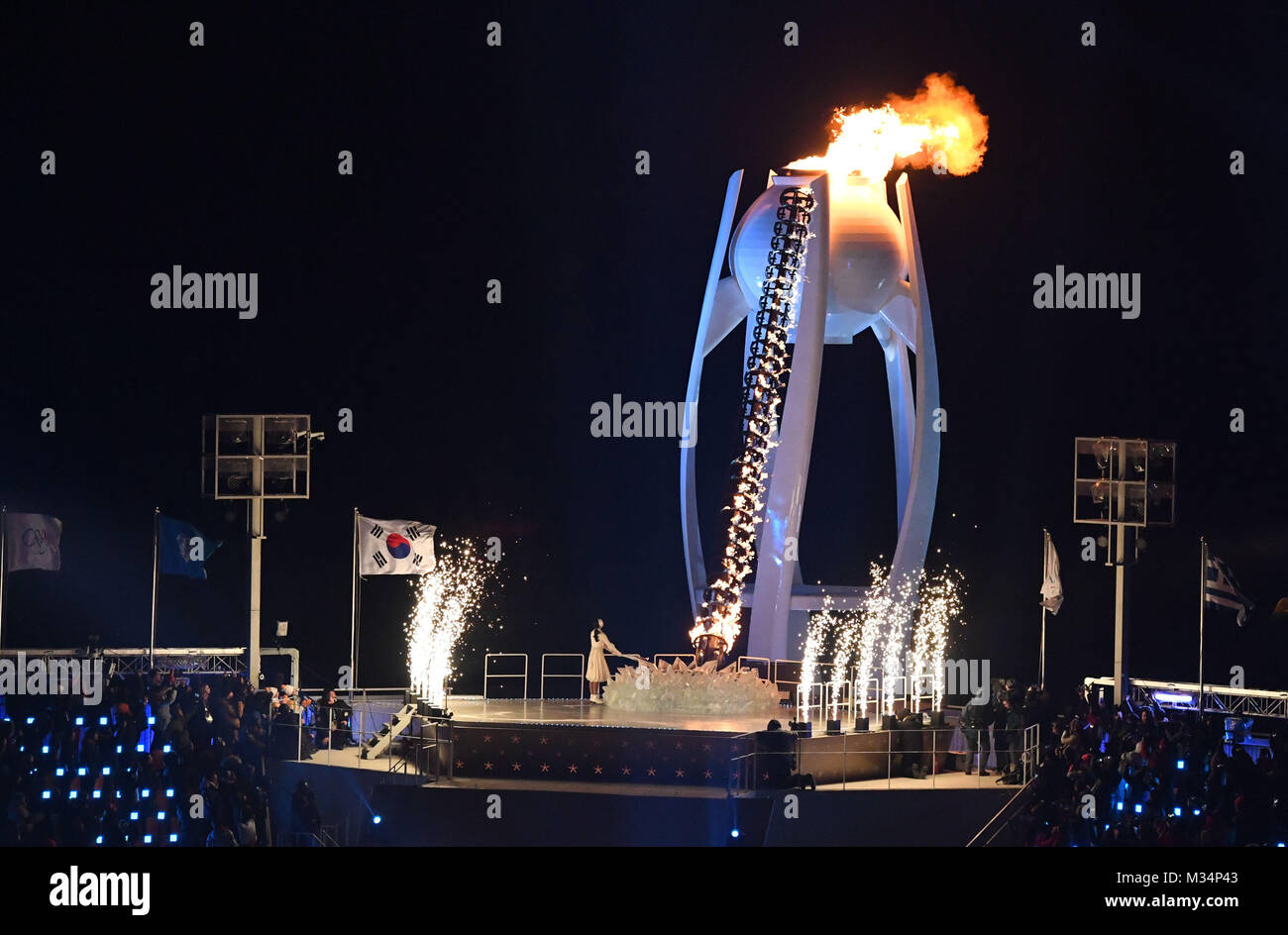 The olympic torch is lit during the ceremony hi-res stock photography ...
