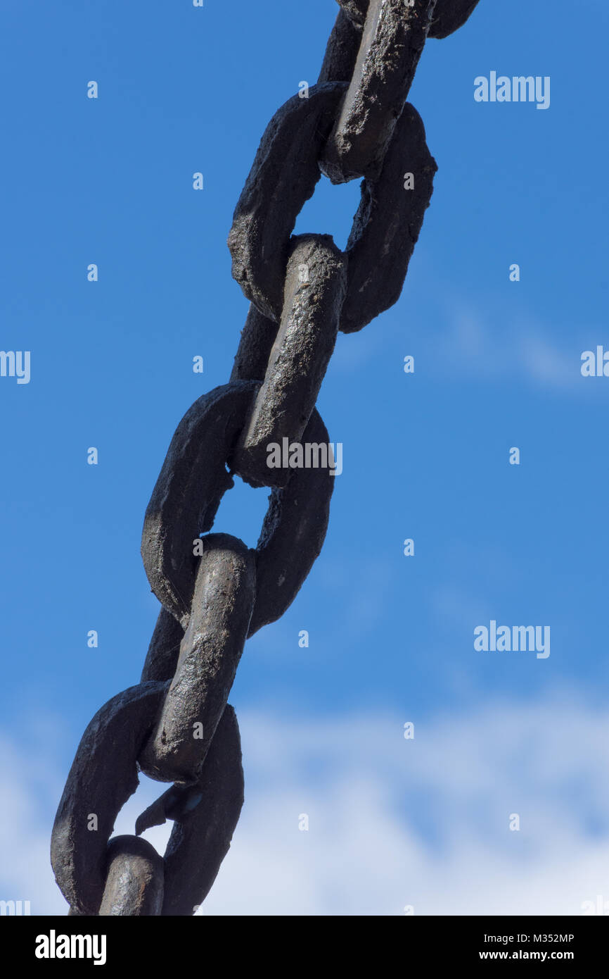 Close up of a large black metal chain photographed diagonally against ...