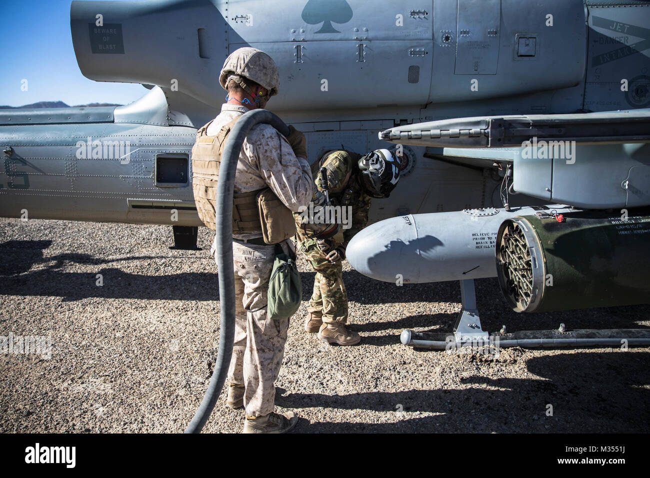 A Marine with Marine Wing Support Squadron 371 carries a jet fuel line ...