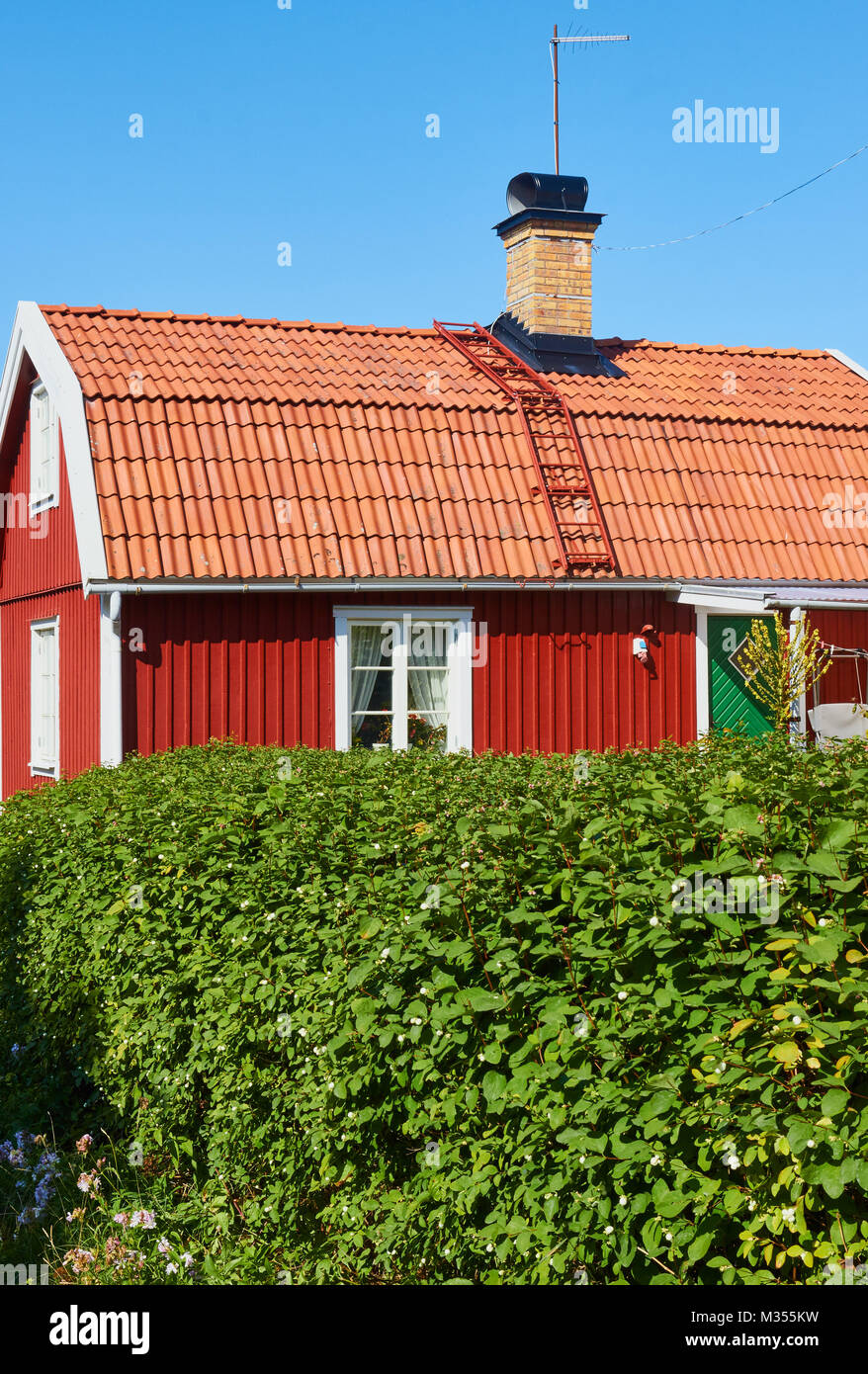 Traditional Swedish timber house behind hedge, Stockholm archipelago ...
