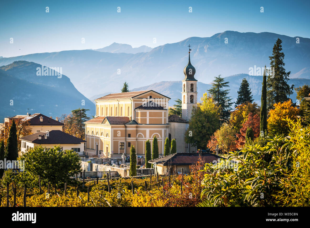 Beautiful autumnal landscape with church and Alps in Trento, the ...