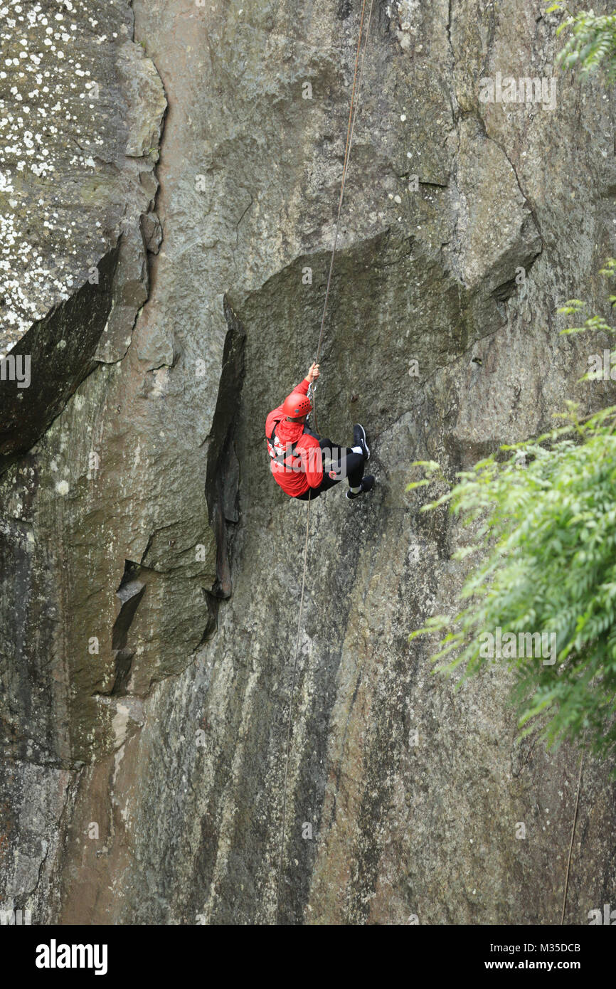 Man abseiling down a rock face in Cathedral quarry, Little Langdale in ...