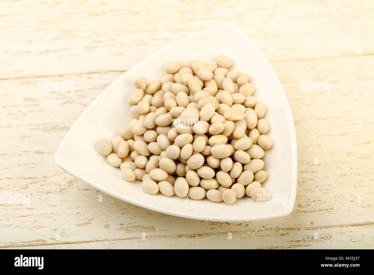 Dry white beans in the bowl over wooden background Stock Photo - Alamy