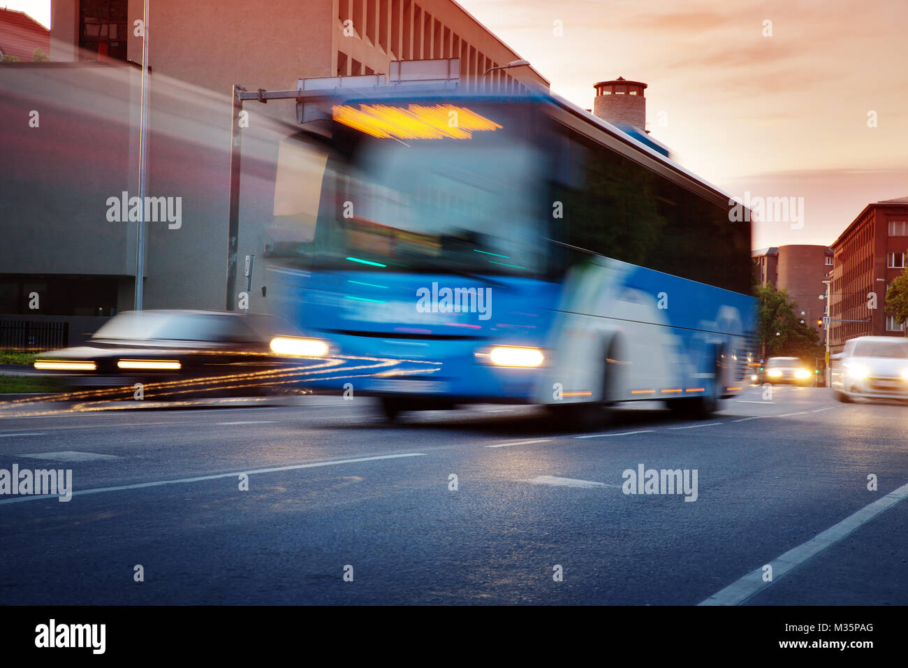 Bus moving on the road in city in early morning Stock Photo - Alamy