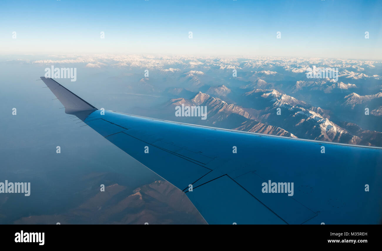 Looking through the window aircraft during flight a snow covered ...