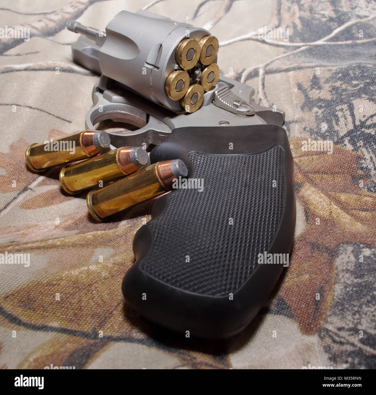 A loaded, stainless steel 44spl revolver on a camouflage background ...