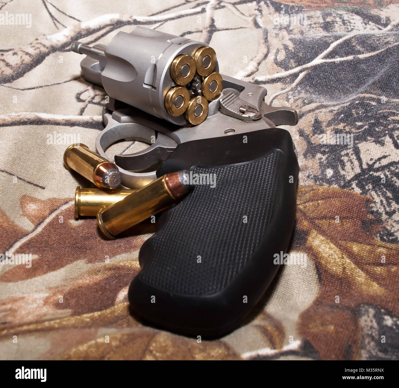 A loaded, stainless steel 44spl revolver on a camouflage background ...