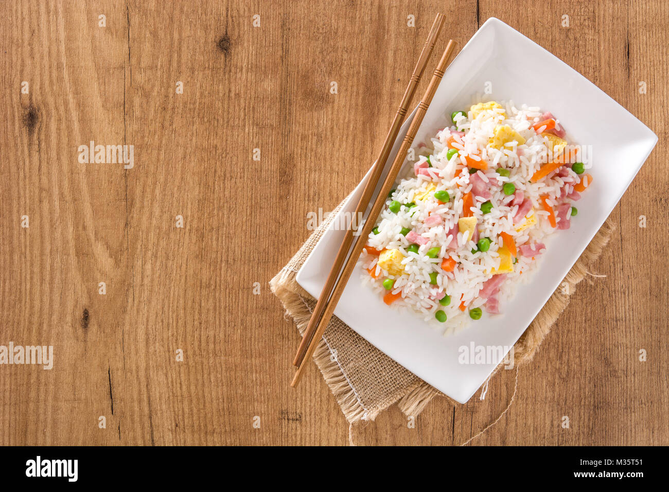 Chinese fried rice with vegetables and omelette on wooden table Stock ...
