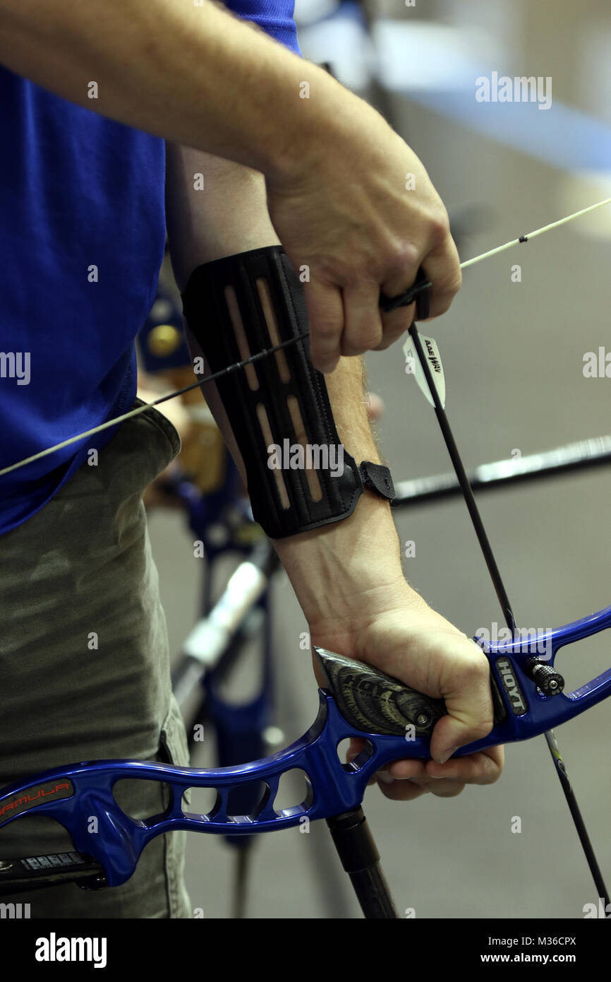 An archer prepares to draw his bow and take aim at his target at the ...