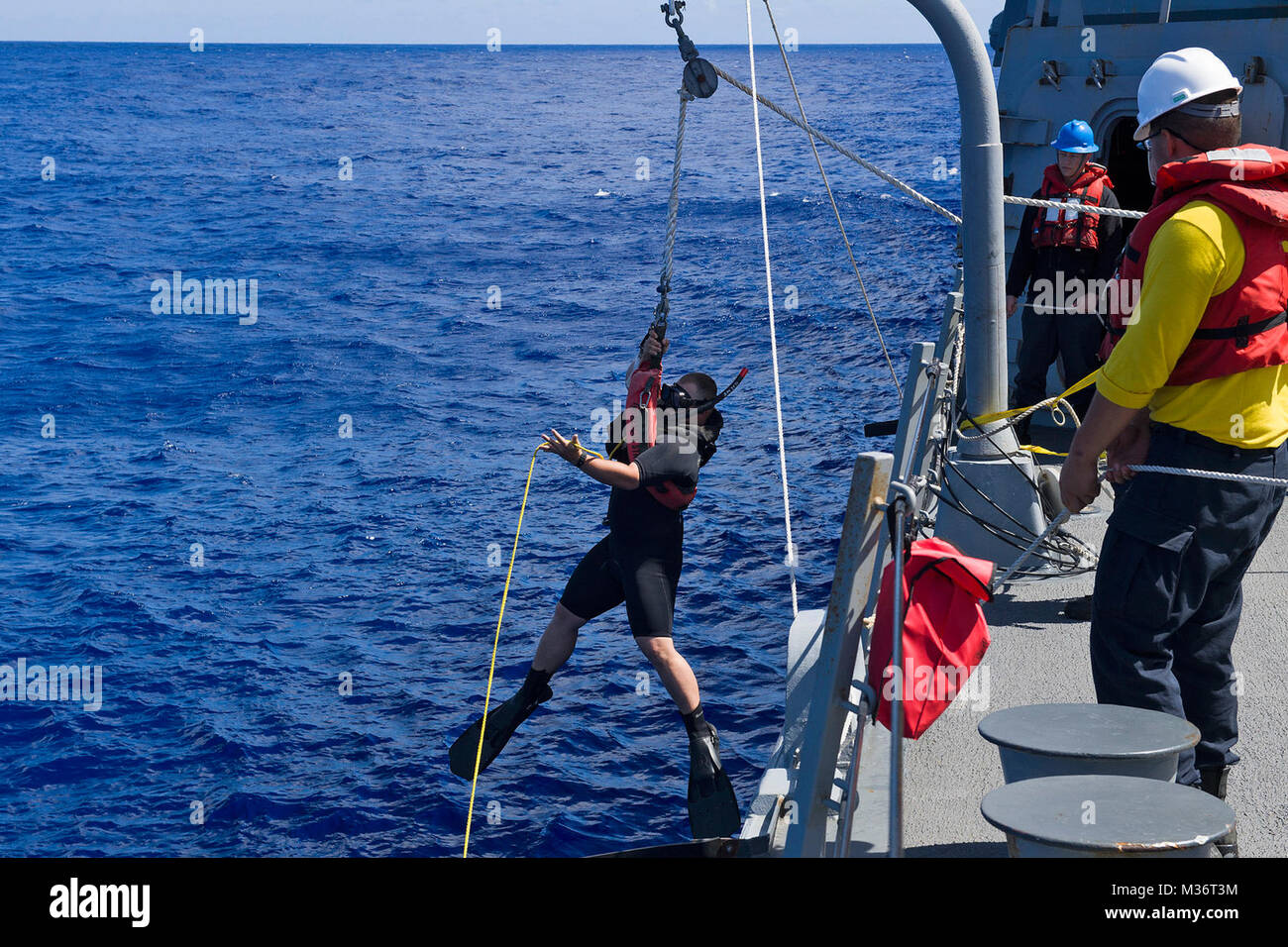 Sailors conduct rescue swimmer over the starboard side of USS Sterett ...