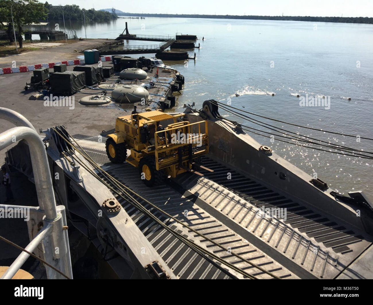 A forklift driver drives up the ramp of expeditionary fast transport ...