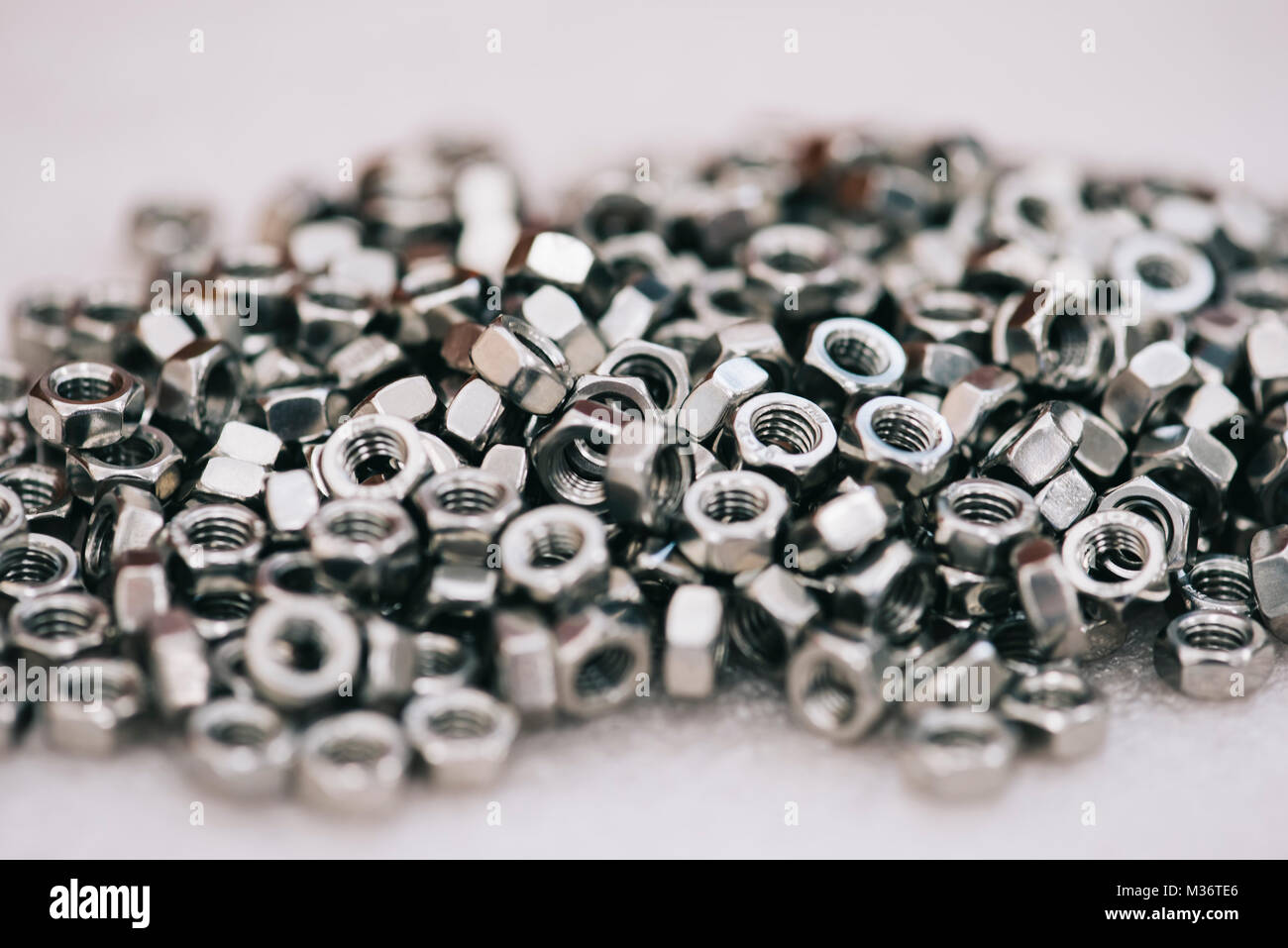Industrial metal nuts background, close up view Stock Photo - Alamy
