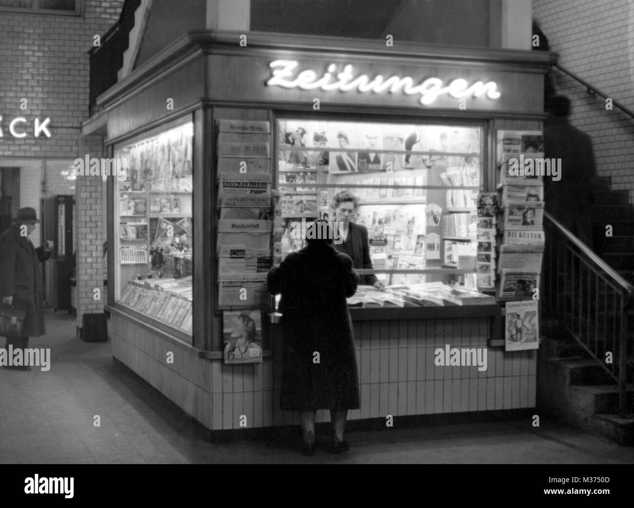 A newspaper stand in a train station, photographed in the 1950s ...