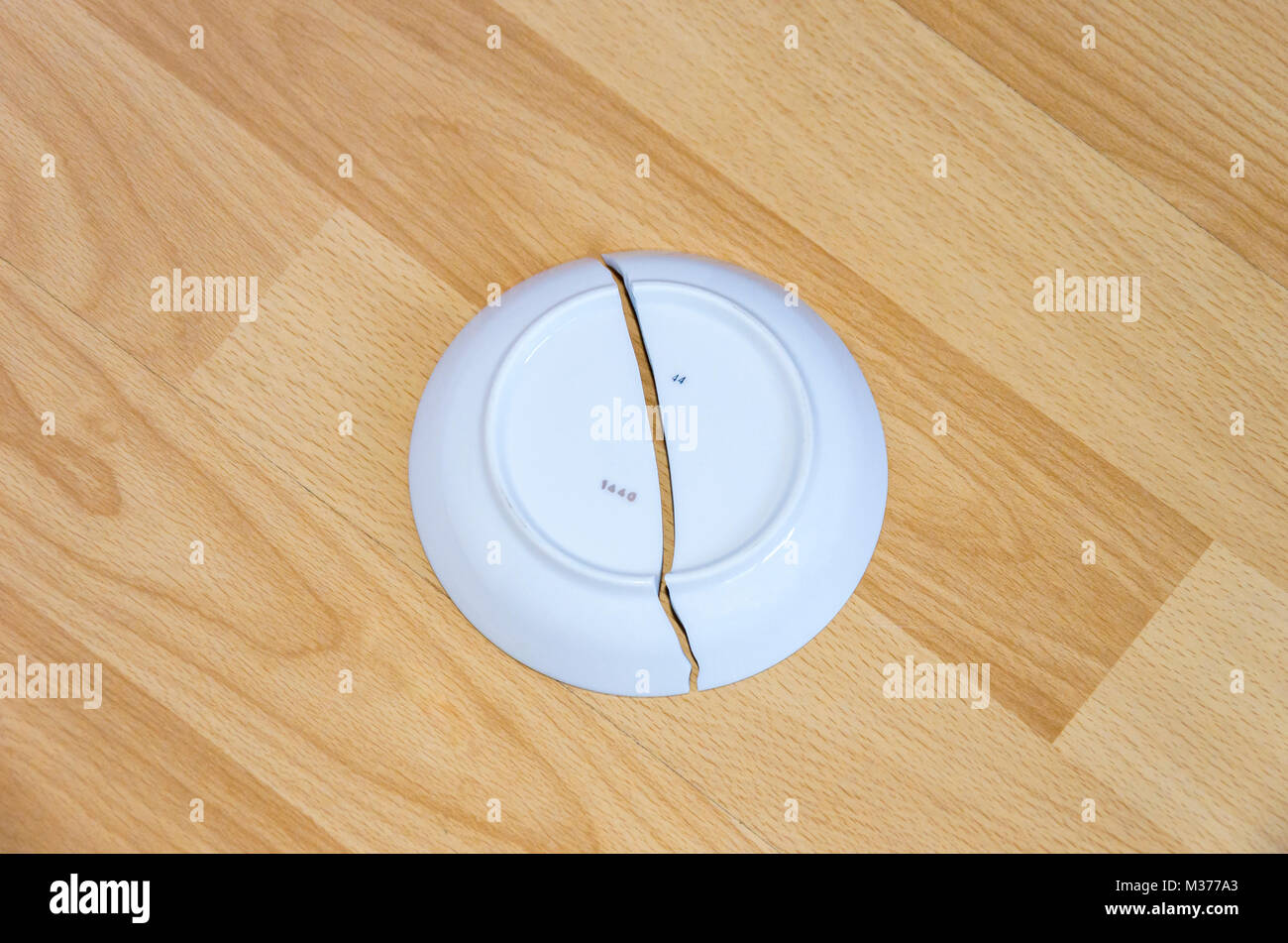 Broken china plate on the floor Stock Photo - Alamy