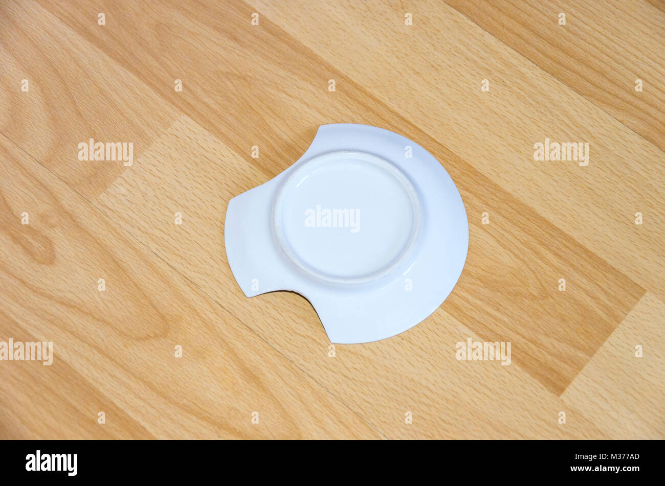 Broken china plate on the floor Stock Photo - Alamy