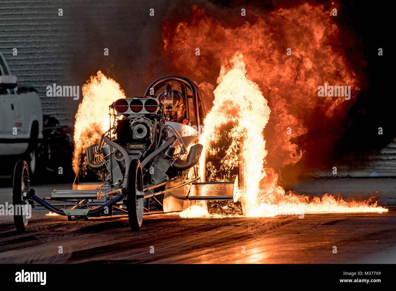 A drag racing car is engulfed in flames during a run at Santa Pod ...
