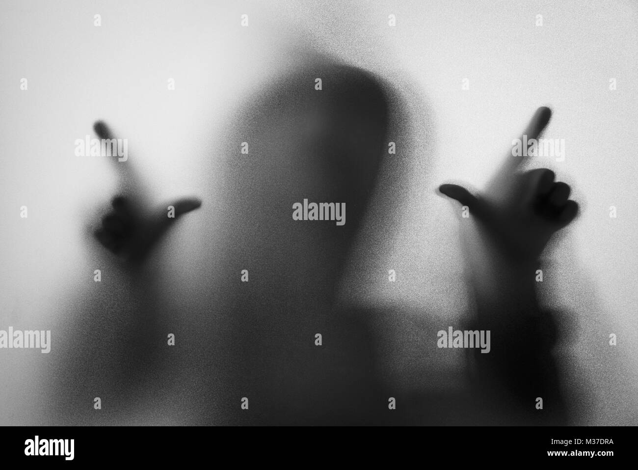 Shadow blur of horror man in jacket with hood.Hands on the glass ...