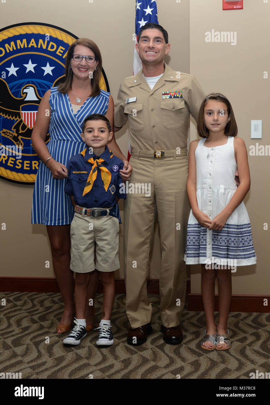 Lieutenant Commander Keith Bushey pose for a family photo following his ...
