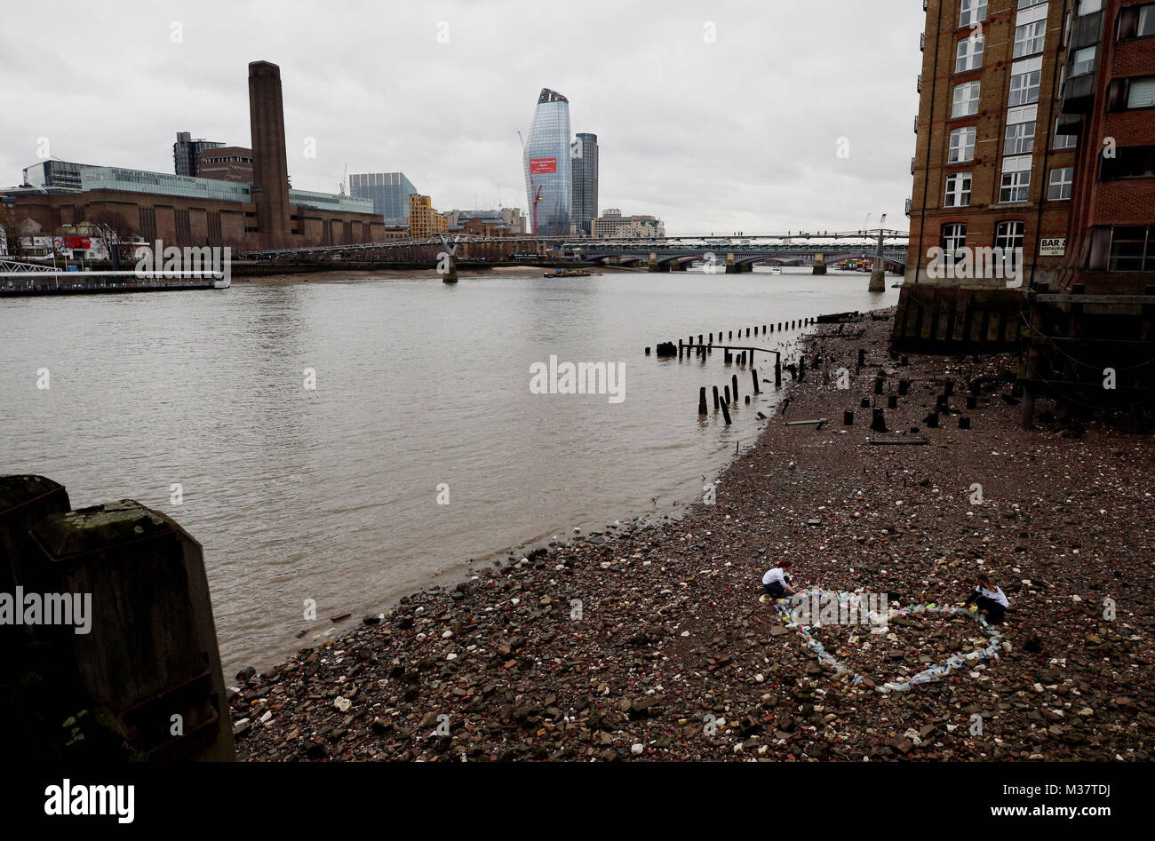 Volunteers create a heart shaped collection of plastic bottles ...