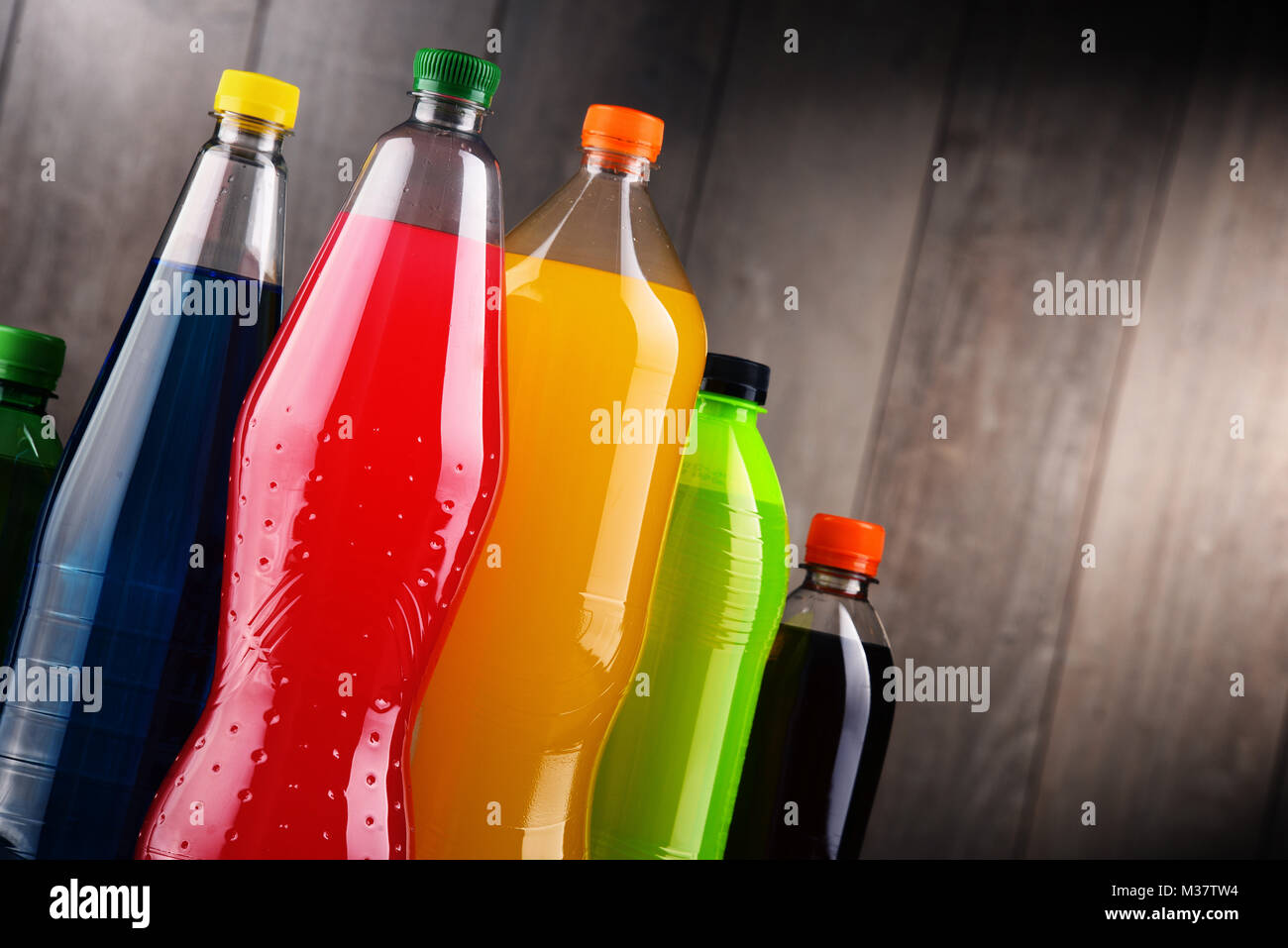 Plastic bottles of assorted carbonated soft drinks in variety of colors ...