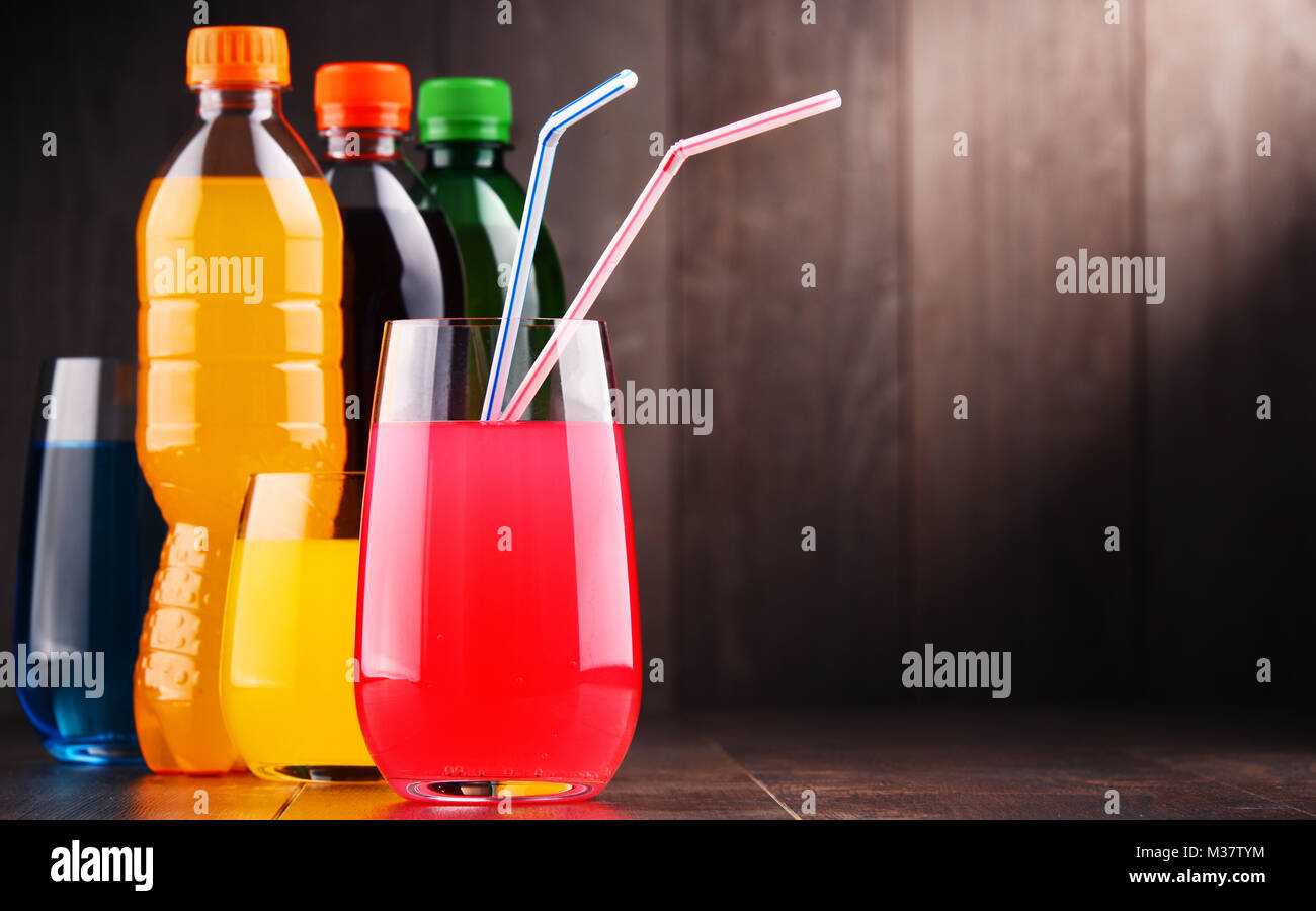 Glasses and bottles of assorted carbonated soft drinks in variety of ...