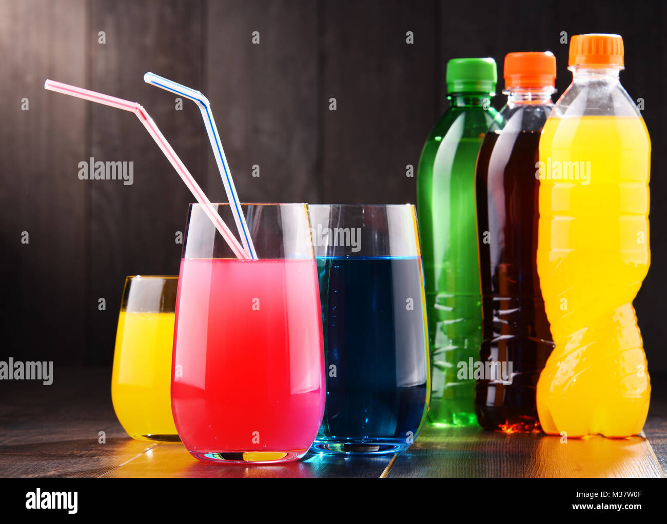 Glasses and bottles of assorted carbonated soft drinks in variety of ...