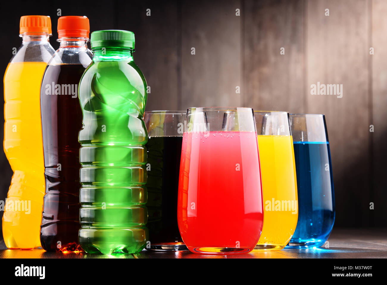 Glasses and bottles of assorted carbonated soft drinks in variety of ...