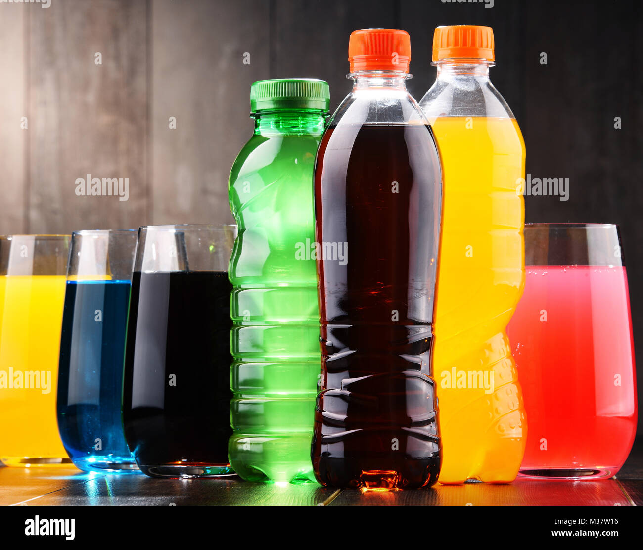 Glasses and bottles of assorted carbonated soft drinks in variety of ...