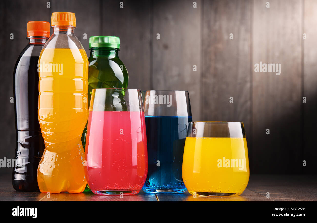 Glasses and bottles of assorted carbonated soft drinks in variety of ...