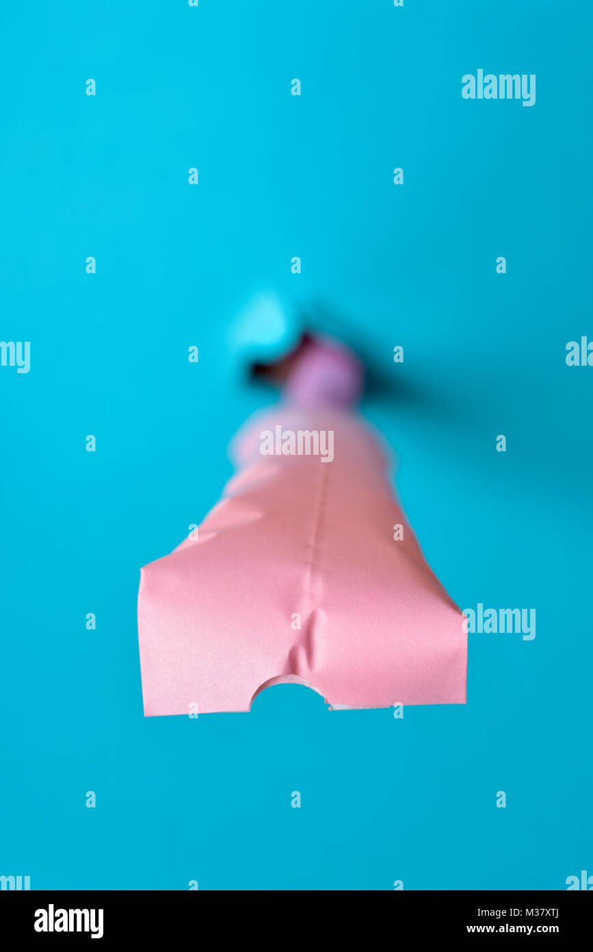 closeup of an unrolled pink blower emerging from a bright blue ...