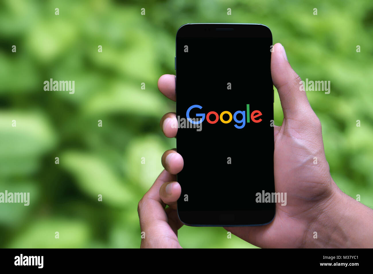 Man with mobile phone showing logos Stock Photo - Alamy