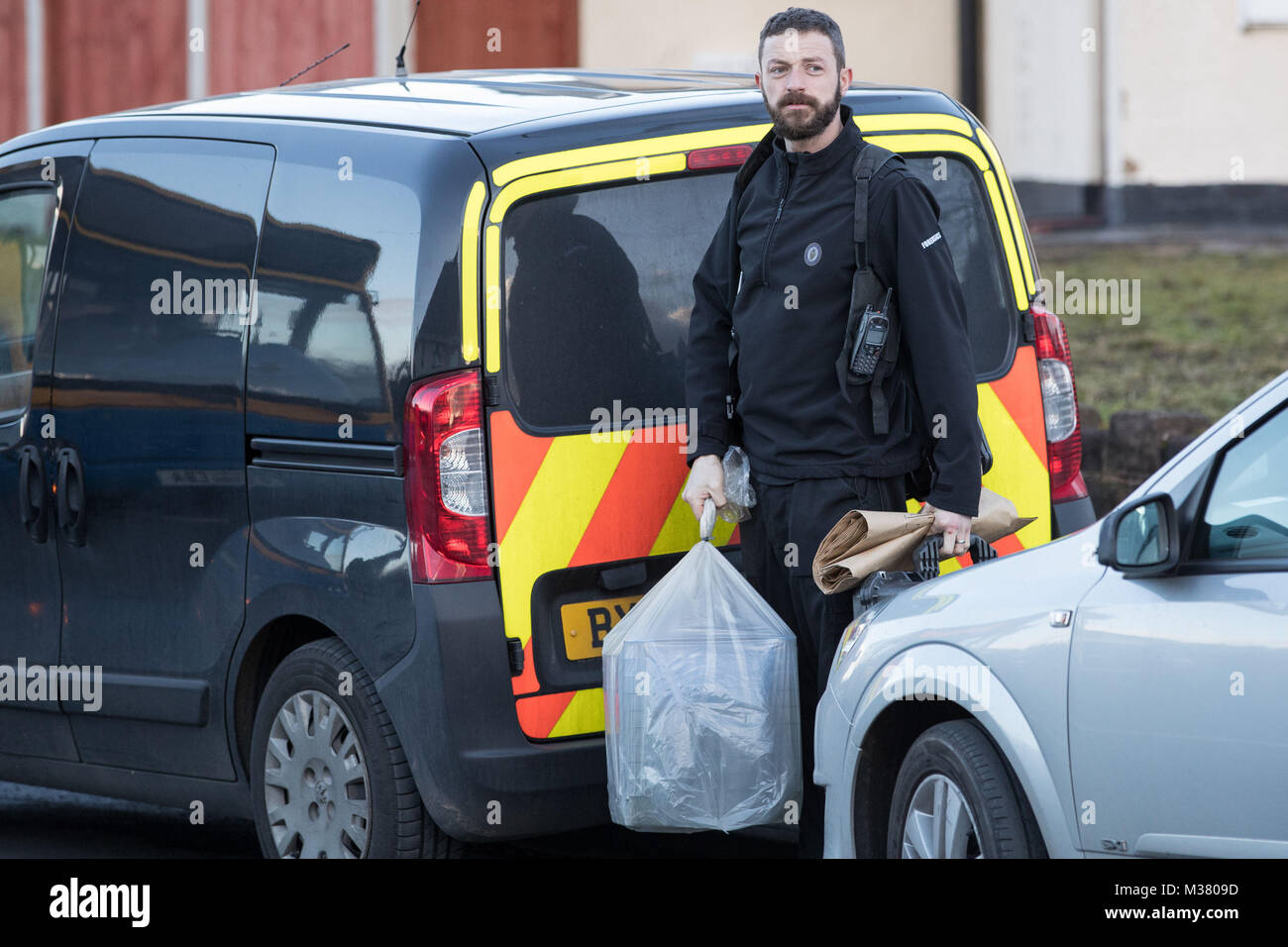 A forensic police officer carries bags along Kent Road, Wolverhampton ...