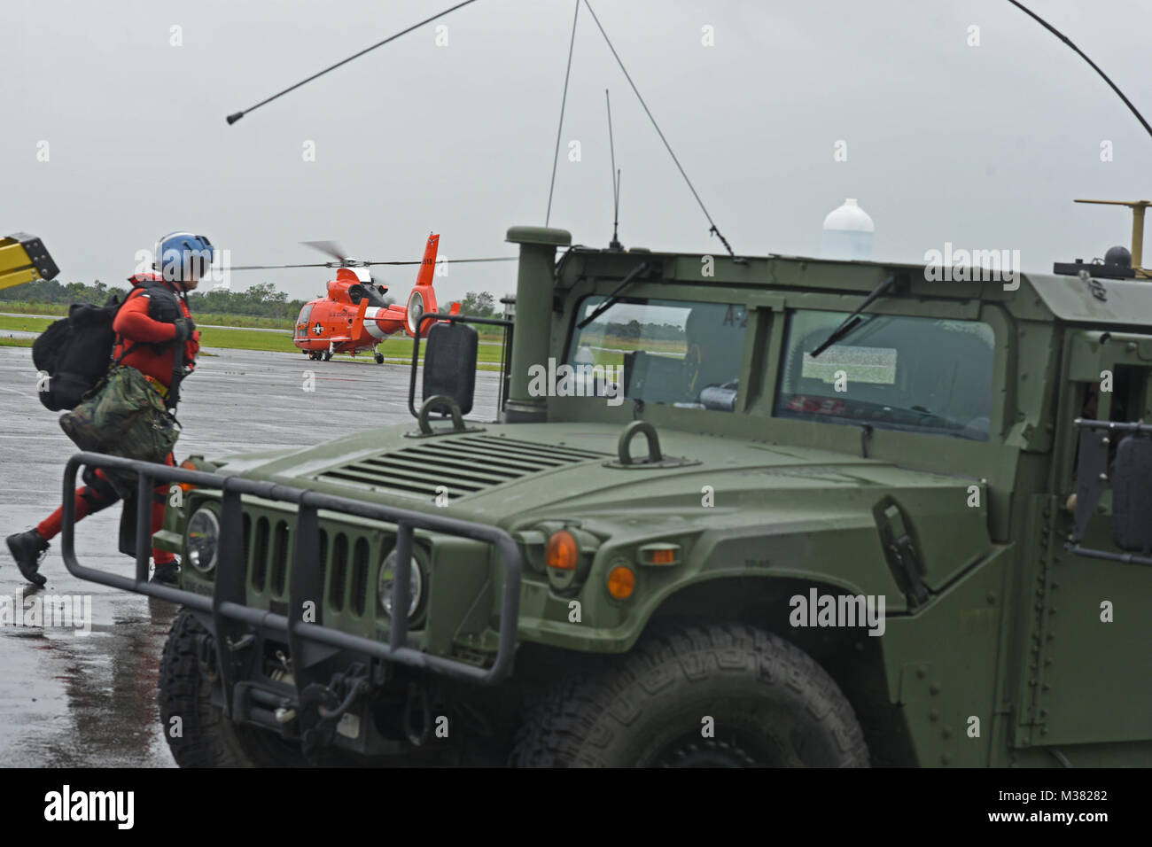 A Coast Guard rescue swimmer walks past a Louisiana Air National Guard ...