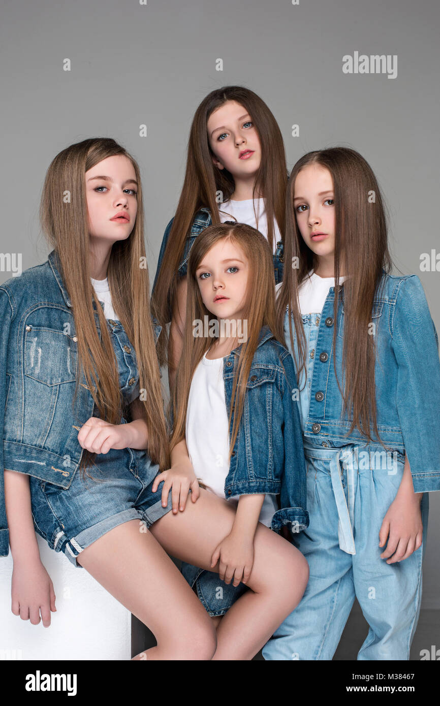 Three happy girls sitting together and looking at camera. Isolated over ...