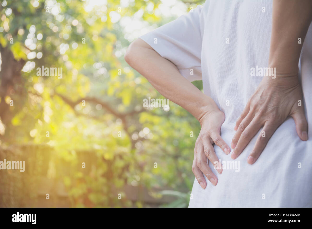 A woman suffering from backache, spinal injury and muscle issue problem ...