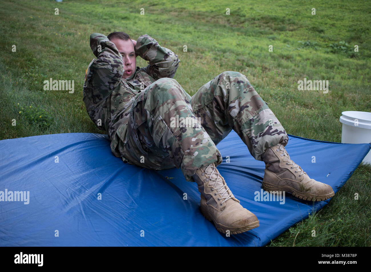 A Soldier from the Maine Army National Guard does sit-ups while being ...