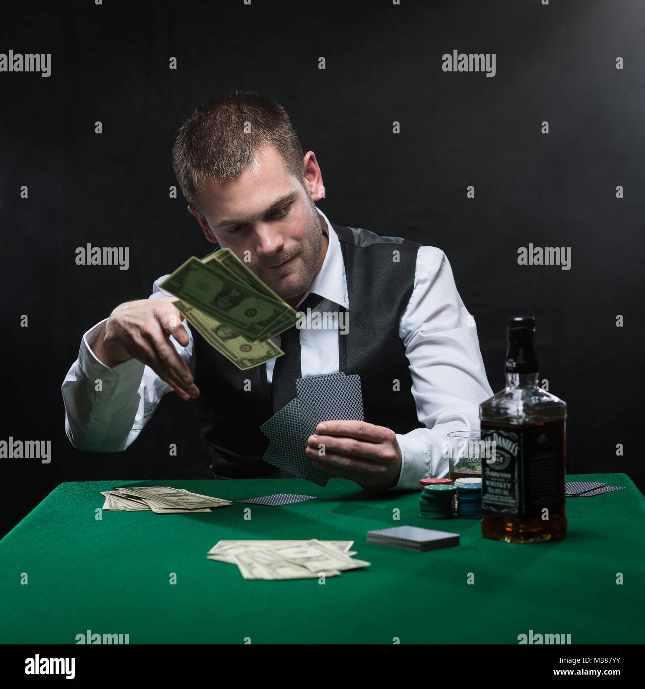 Tough guy playing his cards close to his chest at the poker table Stock ...