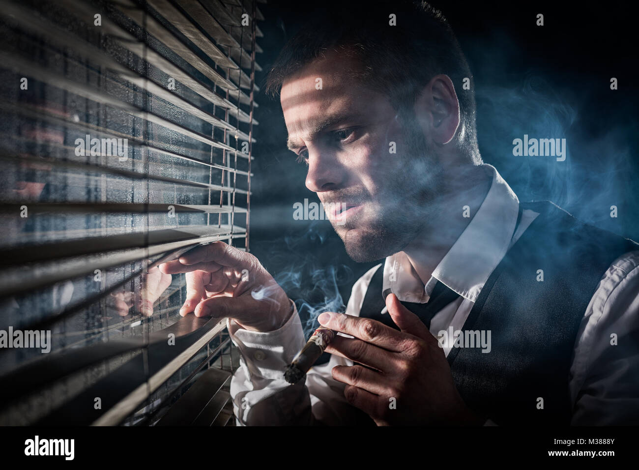Gangster smoking a cigar while looking out the window at a car ...