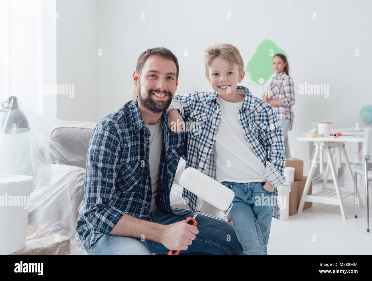 Home makeover, decoration and painting: a father is posing with his son ...